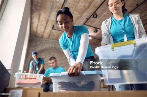 도움이 필요한 사람들을 위해 기부 상자를 포장하는 자원 봉사자의 모습 아래 Charitable Foundation에 대한 스톡 사진 및 기타 이미지 Charitable