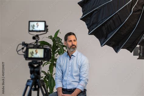 Behind The Scenes Of Man Sitting On Chair On Video Production Set In