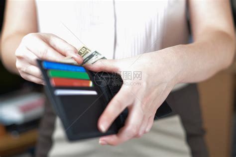 女人手里拿着钱的黑色钱包高清图片下载 正版图片504168090 摄图网