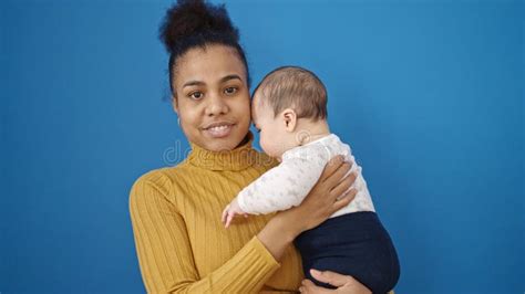Mother And Son Smiling Confident Hugging Each Other Over Isolated Blue