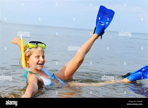 La Fille Sur Le Littoral Dans Un Masque Palmes Et Avec Un Tuba Photo
