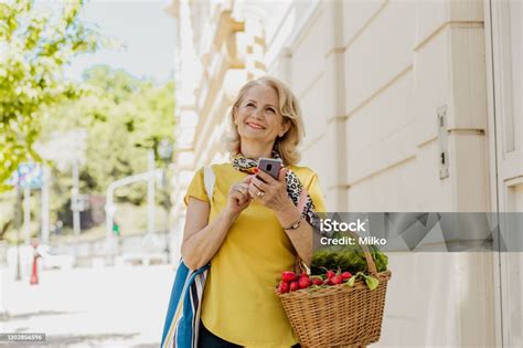길거리에서 식료품과 휴대 전화로 가득 찬 쇼핑 바구니를 가진 노인 여성 시장 소매점에 대한 스톡 사진 및 기타 이미지 시장 소매점 휴대전화 65 69세 Istock