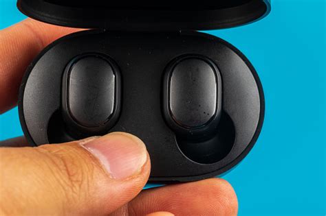 파란색 배경에 격리 된 무선 블루투스 헤드폰을 가진 남자 손 건강관리와 의술에 대한 스톡 사진 및 기타 이미지 건강관리와 의술 귀 부분 노트북 Istock