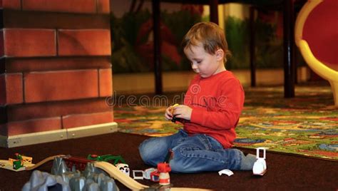 Bambino Carino Che Gioca Da Solo Con Un Treno Di Giochi Di Plastica Colorato Fotografia Stock