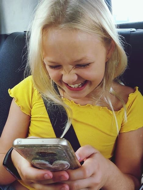 Premium Photo Close Up Of Cute Girl Using Mobile Phone While Sitting