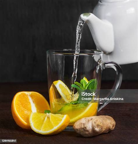 신선한 오렌지와 레몬 조각으로 만든 생강 차 투명 유리 머그잔에 끓는 물을 붓습니다 크리스마스 음료 과일 차 겨울에는 따뜻하게 유지하십시오 레스토랑과 카페 메뉴 크리스마스