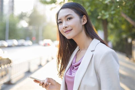 东方人成年人脸头脸颊一个人商务人士商务女性微笑横图室外白天正面度假商务时尚快乐幸福技术美景城市风光