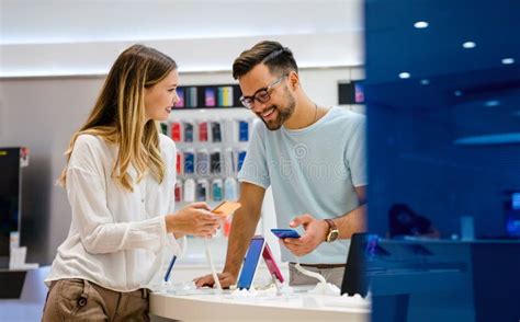 Happy Young People Buying New Smartphone In Mobile Shop Technology