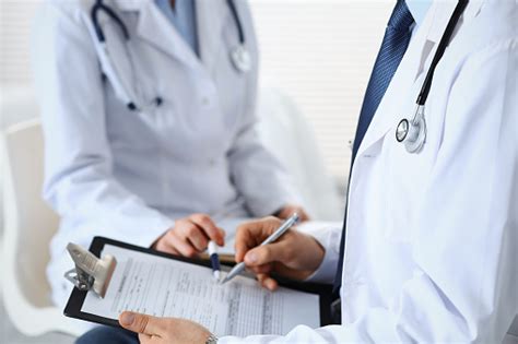 두 알 수 없는 의사 클립 보드에 의료 양식을 작성 그냥 손 근접 촬영 의사는 환자에 게 질문 하거나 약물 프로그램을 논의 합니다 헬스케어 보험 및 의학 개념 의사에 대한