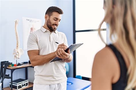 병원에서 클립보드에 쓰는 물리치료사 유니폼을 입은 젊은 히스패닉 남자 남자에 대한 스톡 사진 및 기타 이미지 남자 물리치료 미소 Istock