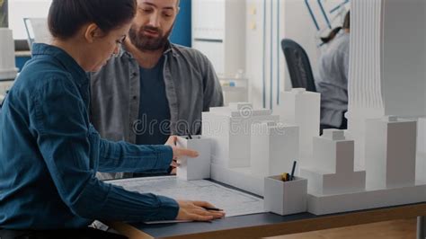 Close Up Of Man And Woman Designing Blueprints Plan Analyzing Building Model Stock Image