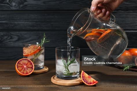 주전자에서 시칠리아 오렌지로 상쾌한 음료를 나무 테이블의 유리에 붓는 여자 근접 촬영 각얼음에 대한 스톡 사진 및 기타 이미지