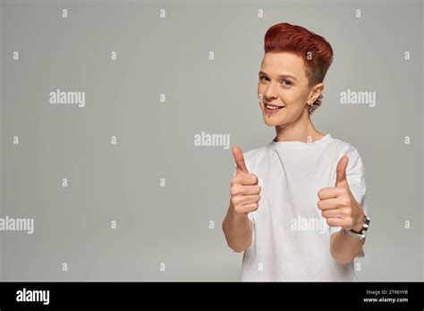 Happy Redhead Non Binary Person In White T Shirt Showing Thumbs And