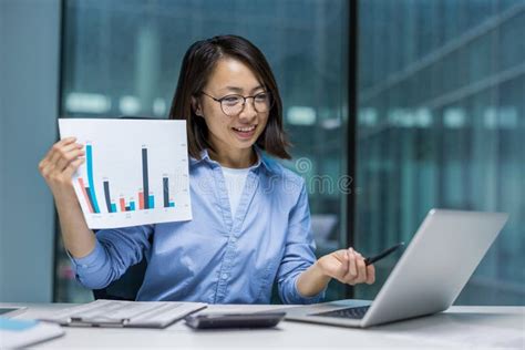 Asian Businesswoman Presents A Bar Graph In A Virtual Meeting Explaining Business Data Stock