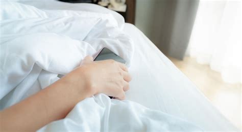 Mulher Dormindo Na Cama E Mão Segurando O Celular Mulher Usando