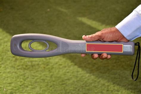 Hand Of A Security Personal Showing Hand Held Metal Detector Stock