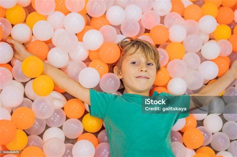 공 구덩이에서 놀고있는 아이 아이들을위한 다채로운 장난감 유치원 또는 유치원 놀이방 탁아 실내 놀이터에서 유아 아이 어린이를위한