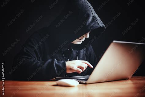 Black Hood Hacker In Hood Using Tablet On Desk To Hacking Privacy