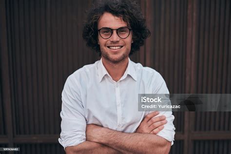 행복 한 잘생긴 젊은 사업가 안경 웃 고 야외에서 포즈의 초상화 남자 학생 갈색 벽에 포즈입니다 흰 셔츠에 똑똑한 사람이 거리에