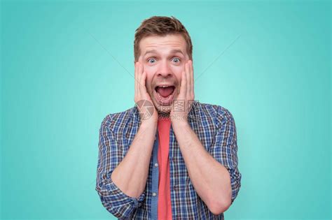 蓝背景脸部表情震惊的年轻男子肖像高清图片下载 正版图片506075622 摄图网