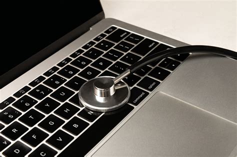 회색 질감 배경에 청진기 키보드가 있는 노트북 현대 의료 기술 소프트웨어 개념입니다 컴퓨터 및 장치의 진단 및 수리 복사 공간 텍스트를 위한 장소입니다 0명에 대한 스톡