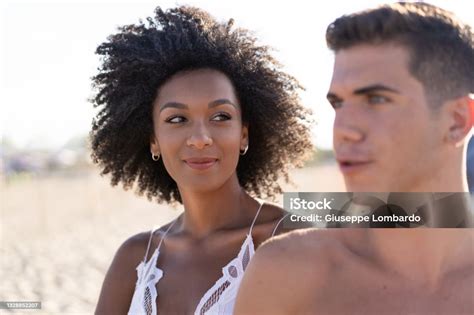 여름에 해변에서 걷고 있는 다인종 커플 남자친구를 보는 소녀의 얼굴을 클로즈업 걷기에 대한 스톡 사진 및 기타 이미지 걷기