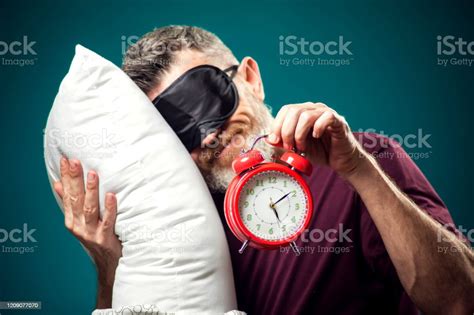 빨간 티셔츠와 수면 마스크를 머리에 시계시계와 베개를 들고 놀란 남자 라이프스타일 및 취침 시간 개념 T 셔츠에 대한 스톡 사진 및 기타 이미지 Istock
