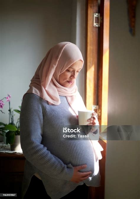 휴식 커피 및 무슬림 임산부는 평화 평온 및 아침 일과를 위해 아기를 생각합니다 행복하고 선하고 이슬람 소녀가 집에서 차 한