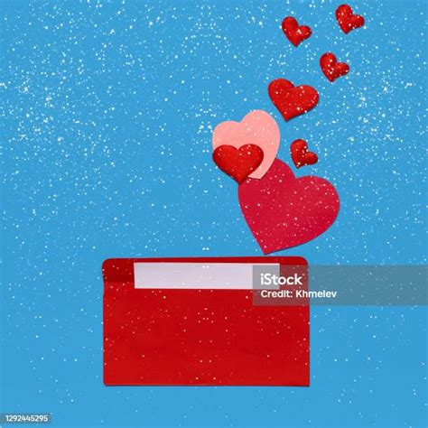 푸른 배경 위에 사랑 편지가 있는 빨간 봉투와 눈송이가 많이 있습니다 봉투에서 하트가 쏟아져 나온다 러브 레터 러브 컨셉 개념에 대한 스톡 사진 및 기타 이미지 Istock