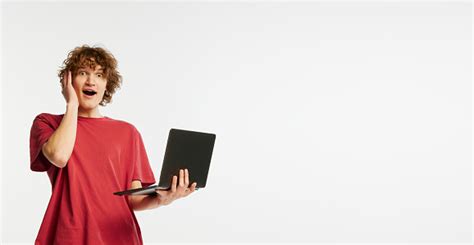 백인 남자의 초상화는 흰색 스튜디오 배경에 고립되어 있습니다 공부를 위해 노트북을 사용하는 감정적 인 소년 인간 감정의 개념 얼굴 표정 20 24세에 대한 스톡 사진 및