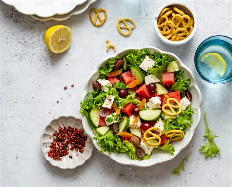 프레즐 한 그릇 옆에 샐러드로 가득 찬 하얀 그릇 사진 Unsplash의 여름 이미지