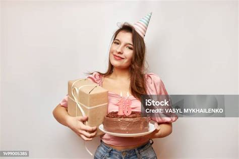 소녀는 숫자 18 형태의 촛불과 선물로 축제 케이크를 들고 있습니다 생일 축하 개념입니다 생일 케이크에 대한 스톡 사진 및 기타 이미지 Istock