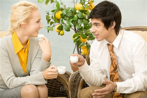 Фотография на тему Два деловых партнера в перерыве пьют кофе сидя в креслах Pressfoto