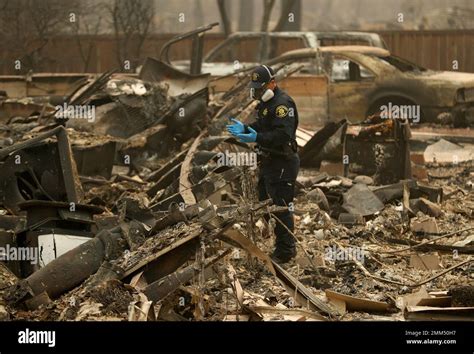 A Sheriff Deputy Looks For Human Remains At A Home Burned In The Camp