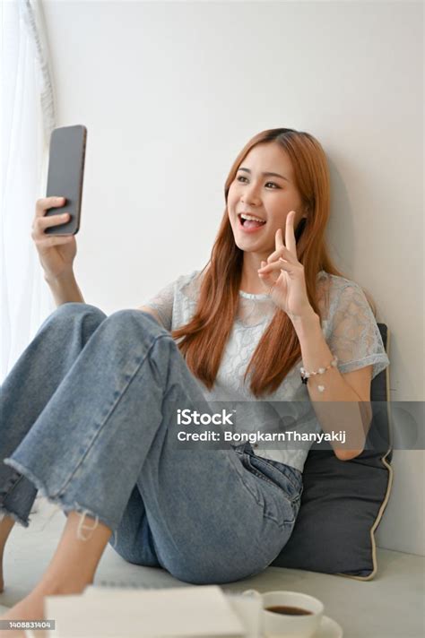 예쁘고 귀여운 젊은 아시아 여성이 V 사인을 만들고 현대 스마트 폰으로 셀카를 찍습니다 20 24세에 대한 스톡 사진 및 기타 이미지 20 24세 Brand Name