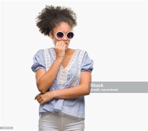 젊은 아프리카 미국 여자 찾고 강조 하 고 손톱을 물어 뜯고 입에 손으로 긴장 고립 된 배경 위에 안경을 착용 불안 문제입니다