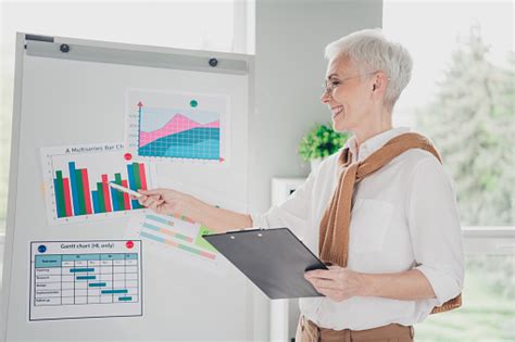 똑똑한 노인 과장 여성 프리젠 테이션 포인트 회의실 그래프 착용 정장 현대 사무실 로프트 룸 인테리어 실내 작업 공간 작업 공간 55 59세에 대한 스톡 사진 및 기타