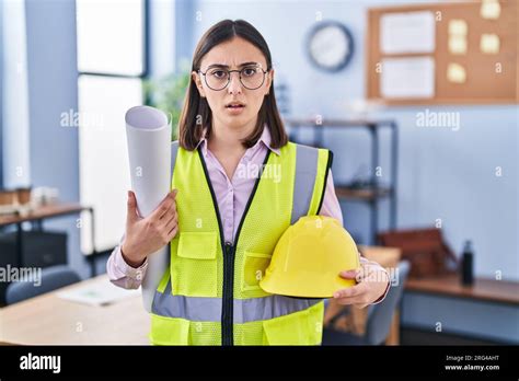 Hispanic Girl Architect Holding Build Project Blueprints Clueless And Confused Expression Doubt