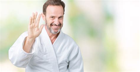 잘생긴 중 년 수석 남자 기모노 행복 격리 된 배경 Waiving 인사를 통해 균일 한 미소 친절 한 환영 제스처를 입고