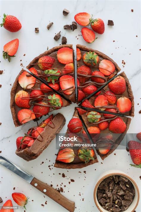 얇게 썬 초콜릿 딸기 타르트 바삭바삭한 코코아 페이스트리 크러스트 딸기로 둘러싸인 녹은 초콜릿으로 이슬비한 딸기 를 얹은 초콜릿 조각 칼 대리석 효과 배경 높은 전망