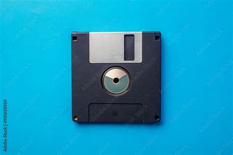 Vintage Floppy Disk Isolated On A Bright Blue Background Symbolizing Outdated Technology
