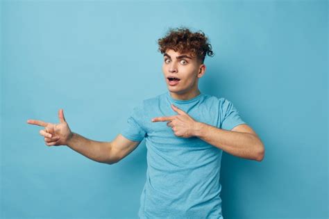 Premium Photo Curly Man In A Tshirt On A Colored Background Posing