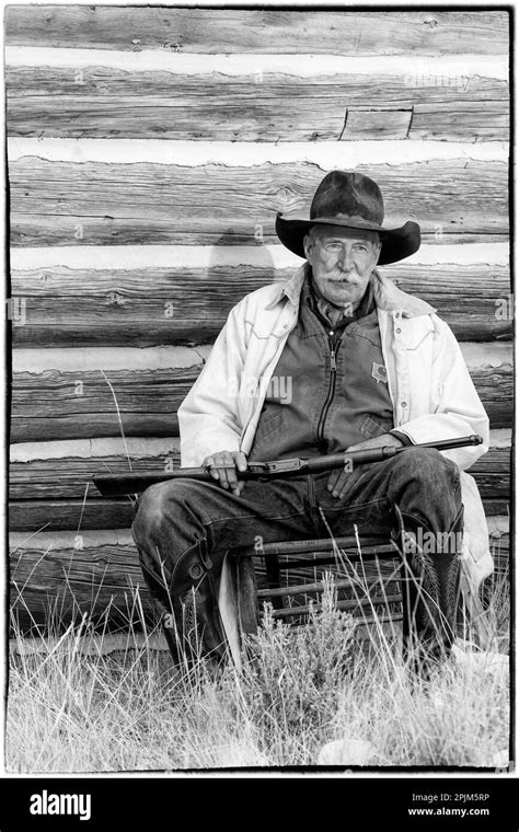 Usa Shell Wyoming Hideout Ranch Cowboy Sitting With His Rifle Against Old Log Cabin Prmr