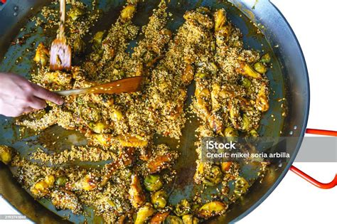 전통적인 스페인 빠에야 요리 두 명의 요리사가 거대한 빠에야 팬에 닭고기와 야채를 넣고 밥을 젓는 클로즈업 흰색 배경에 단계 2 0명에 대한 스톡 사진 및 기타 이미지