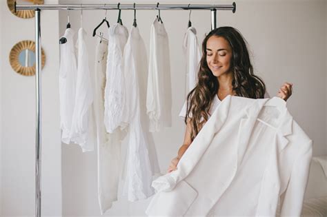 아름다운 젊은 여성 스타일리스트는 흰색 옷을 입고 옷걸이와 랙 근처에 서 많은 옷을 가진 쇼핑 홀릭 30 34세에 대한 스톡 사진 및 기타 이미지 Istock