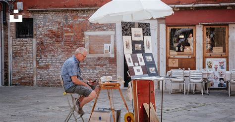 파란색과 흰색 체크 무늬 버튼 업 셔츠를 입은 남자가 의자에 앉아 사진 Unsplash의 무료 도시 이미지