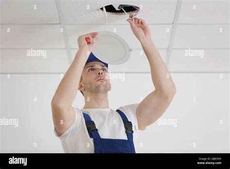Electrician Repairing Ceiling Light Stock Photo Alamy