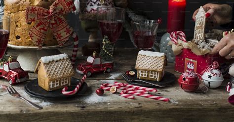 진저브레드 하우스로 테이블을 장식하는 사람 사진 Unsplash의 크리스마스 이미지