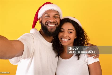 산타 모자에 사랑하는 아프리카 계 미국인 부부는 웃고 노란색 스튜디오 배경 무료 공간에 셀카를 복용 사람들에 대한 스톡 사진 및 기타 이미지 Istock