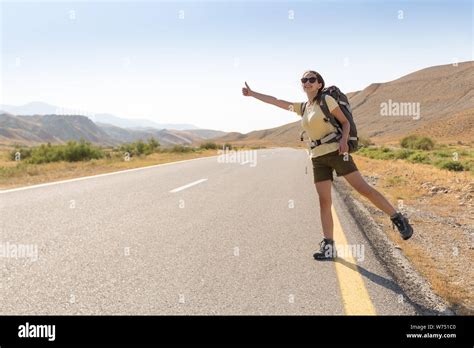 Hitchhiker Traveler Woman On The Road In Sunset Girl Traveler Hiker On